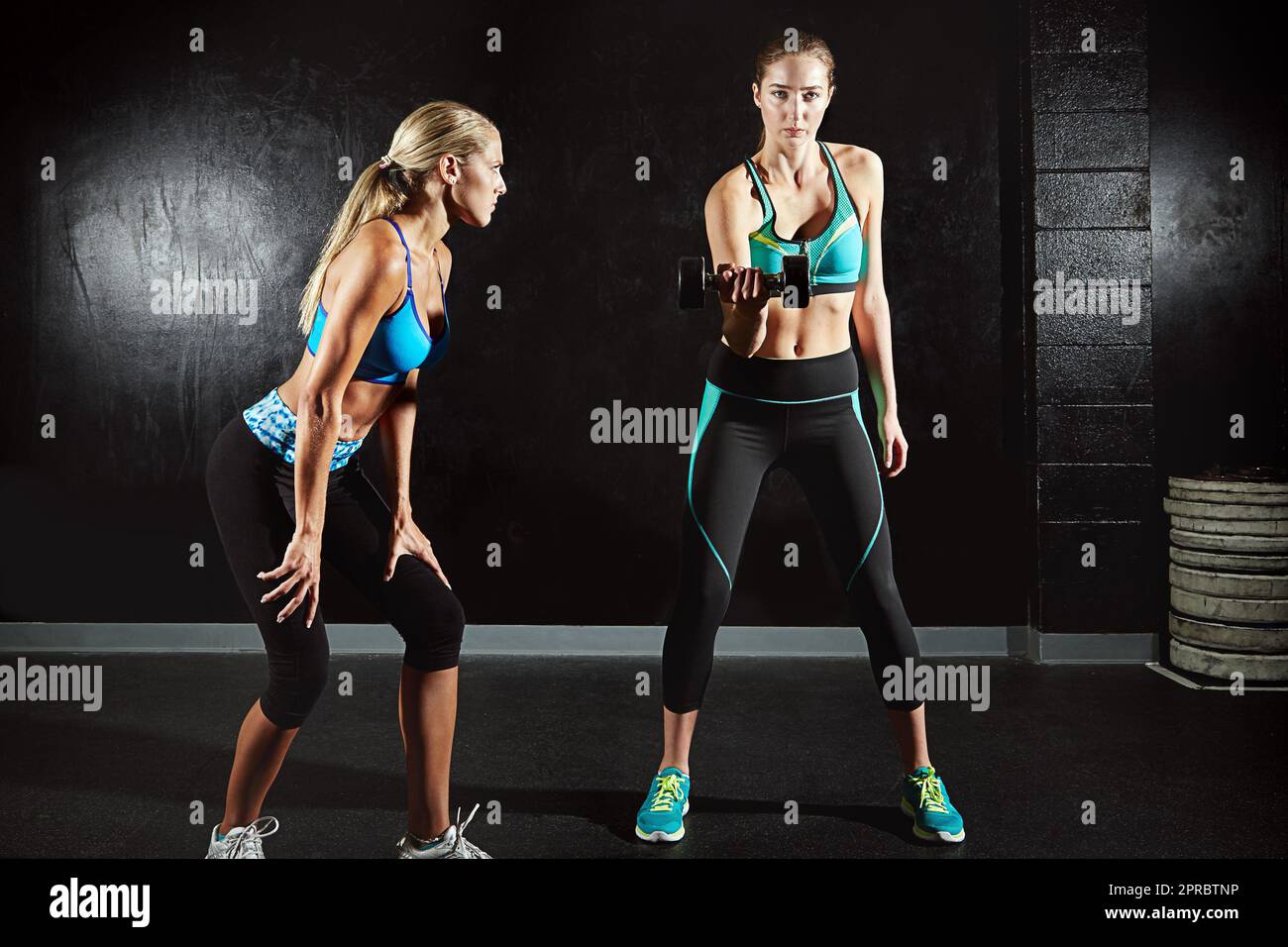 Strong women lift each other up. two young women working out with ...