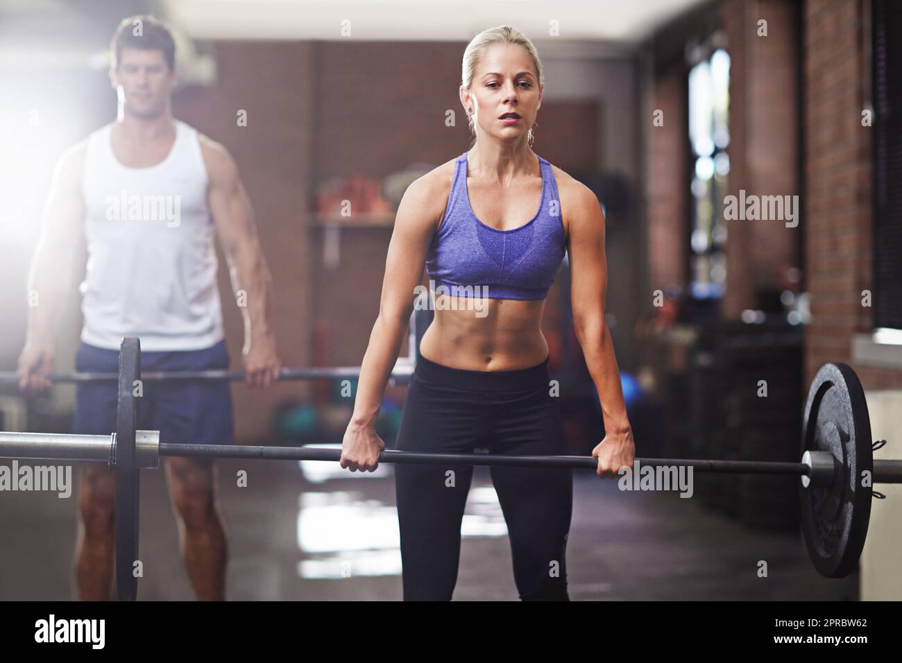 If its easy, it isnt worth it. two people lifting weights in a gym ...
