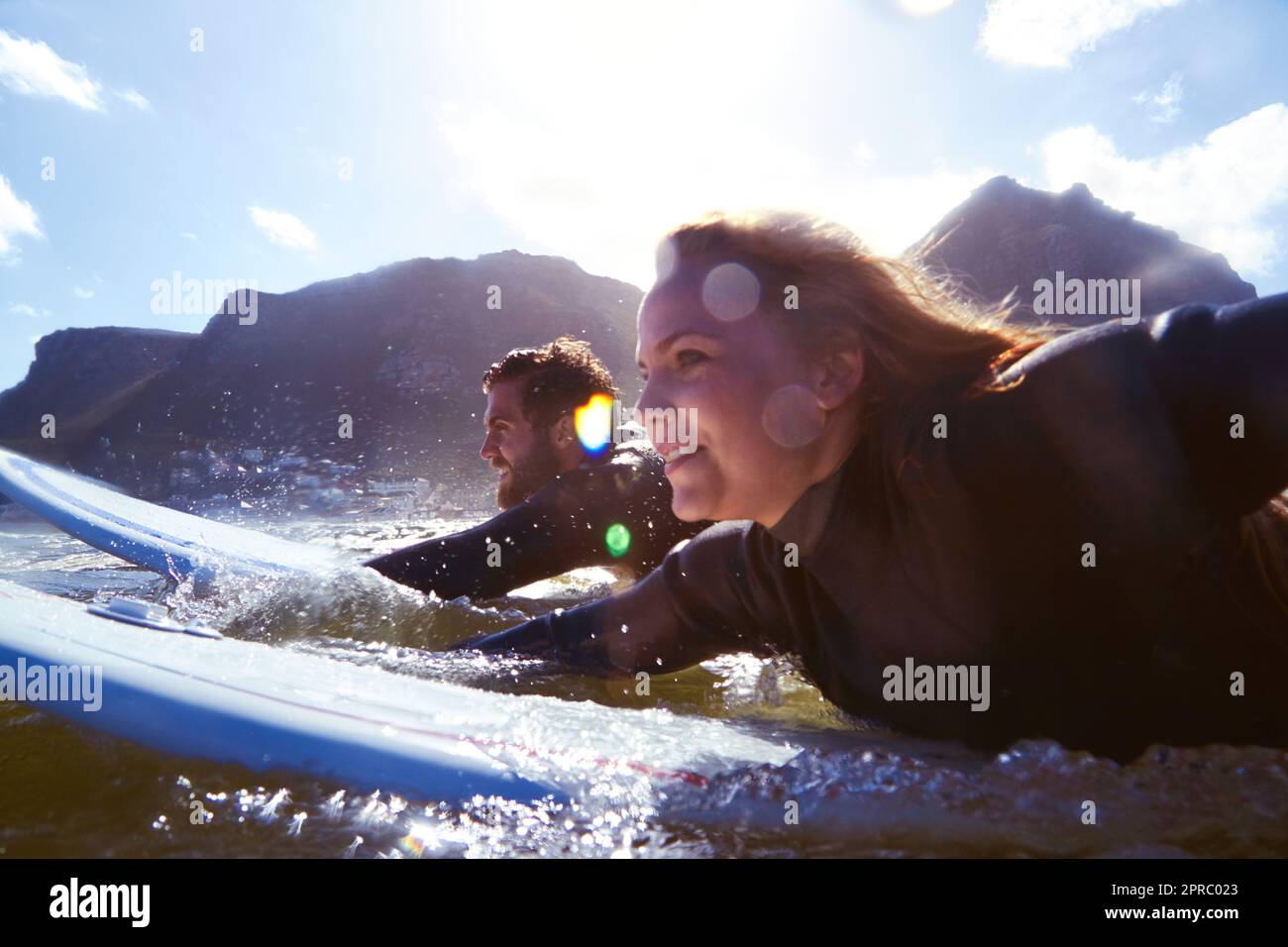 Happy wave riders. an athletic young couple surfing at their favourite ...
