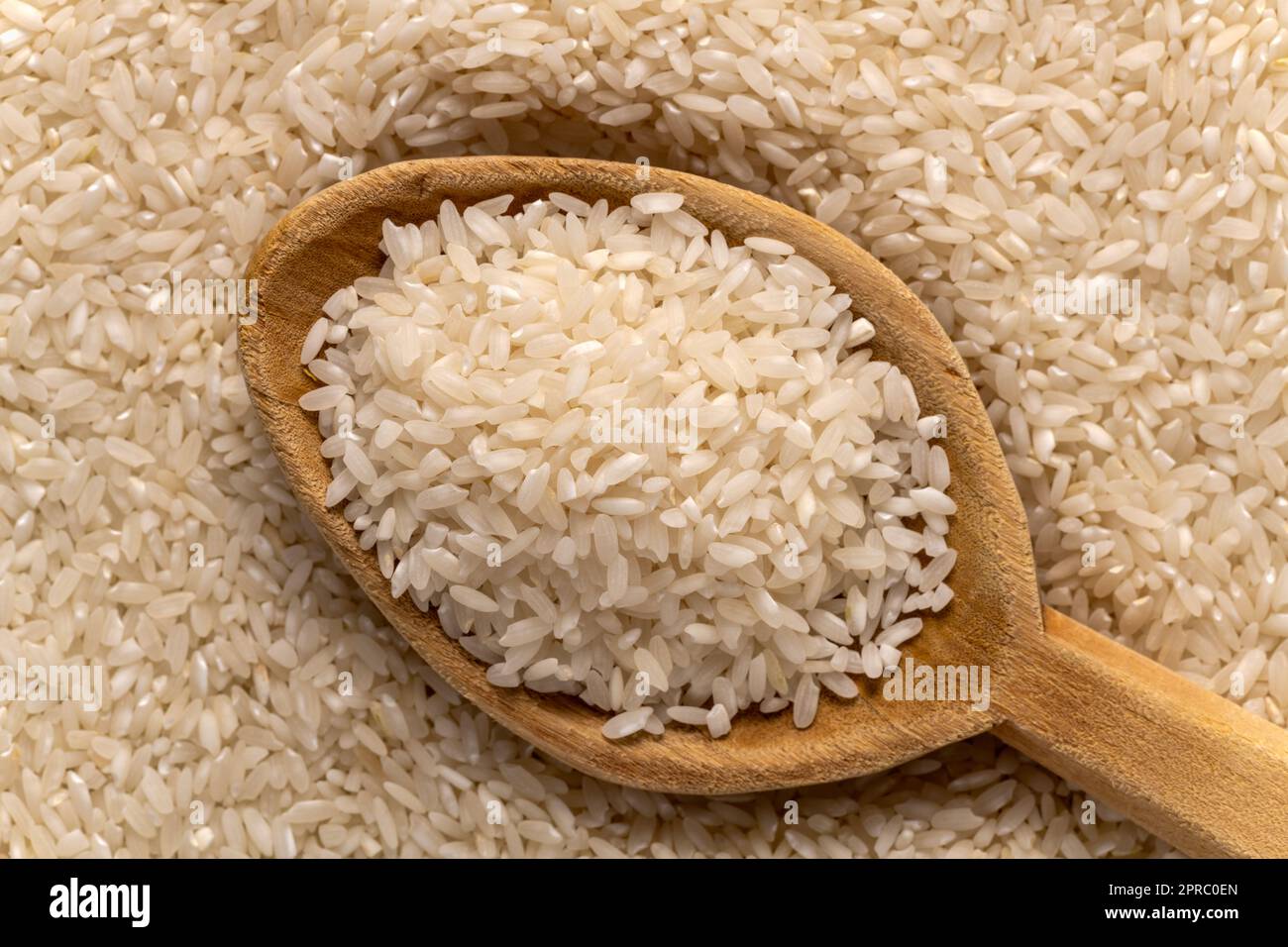 Carolina plantation rice texture background and wooden spoon, closeup ...