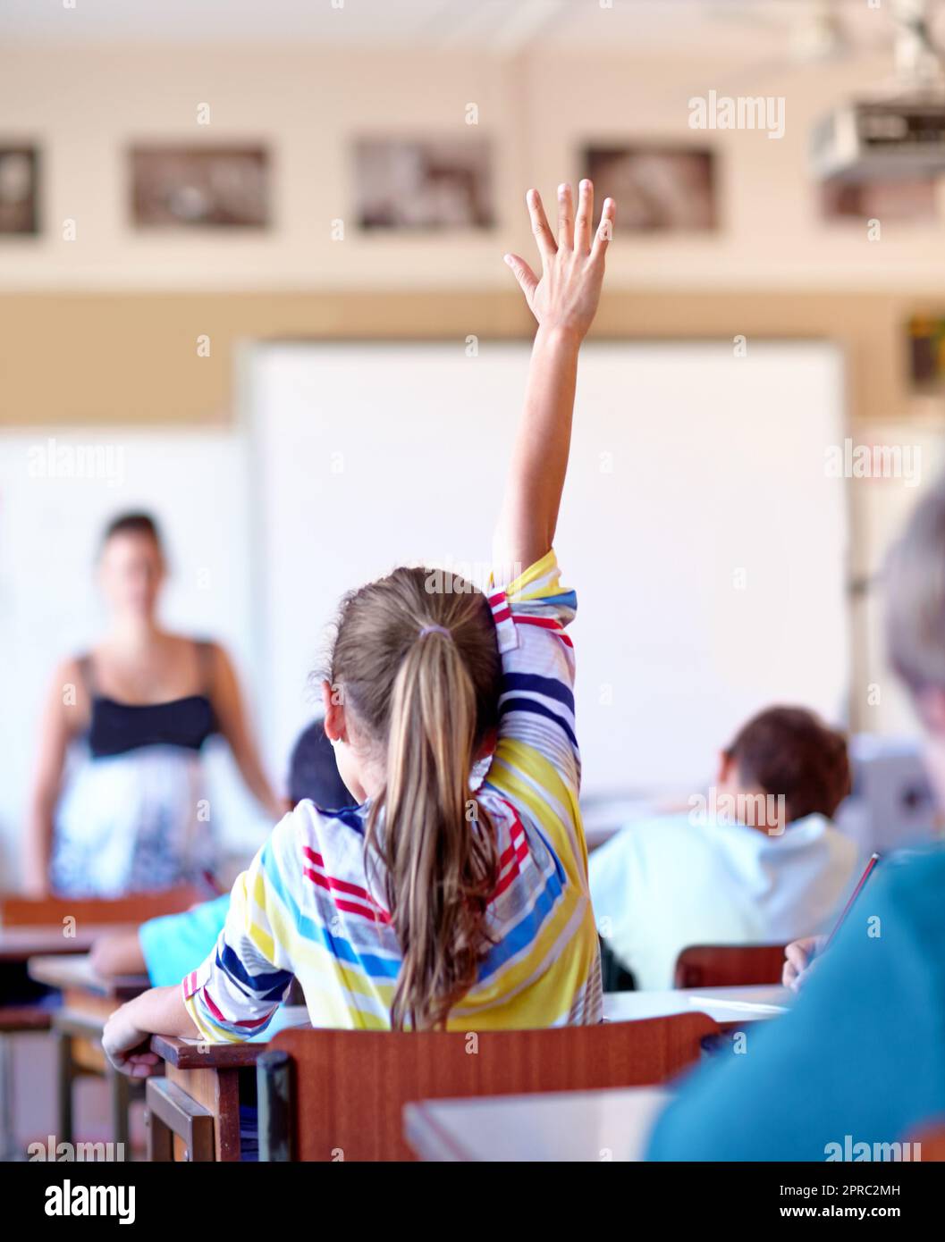 Raising Her Hand A Young School Girl Raising Her Hand To Ask A