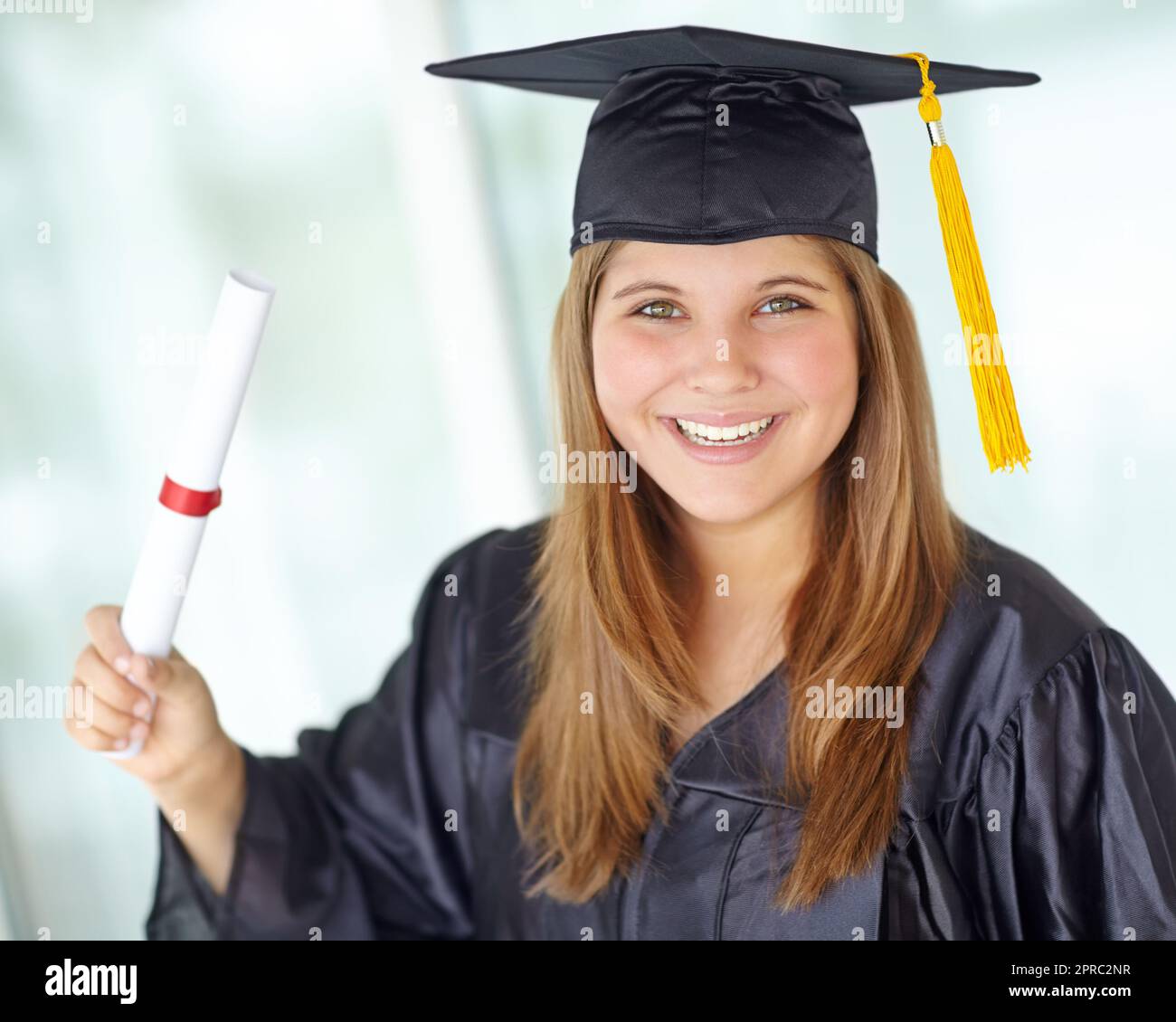 The future is mine. A pretty college student in her graduation gown ...