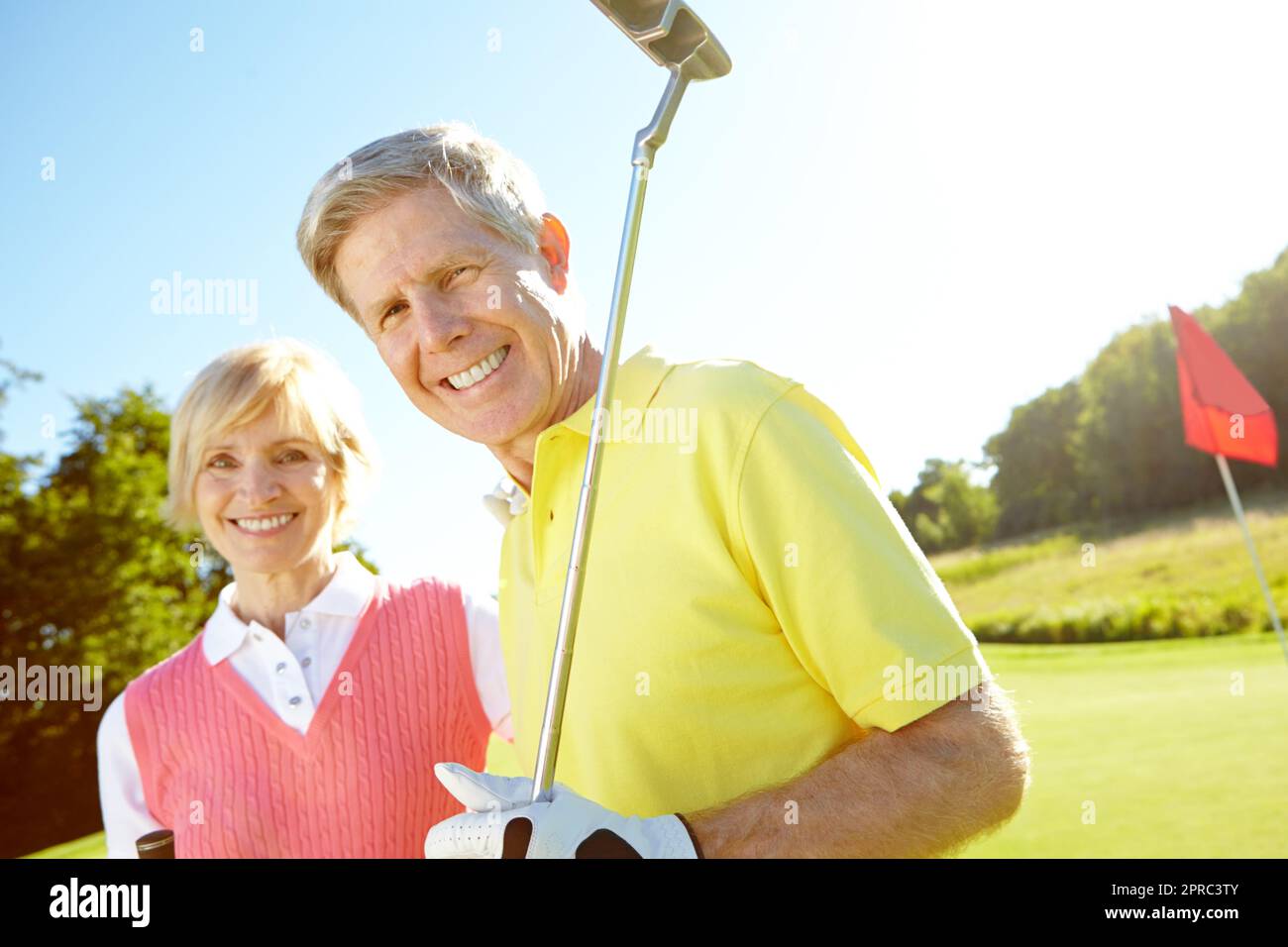 Its the most relaxing sport. Elderly couple holding their golf clubs ...