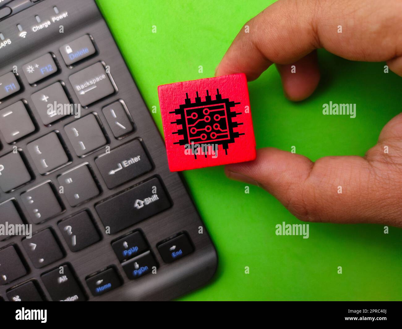 Top view black keyboard with hand holding colored block and microchip ...