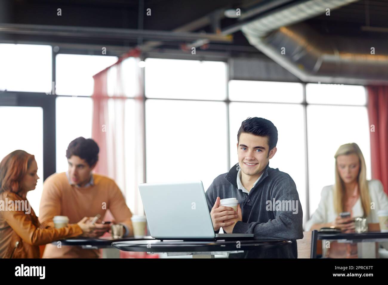 Accessing the local wifi. A handsome young man using his laptop in a ...