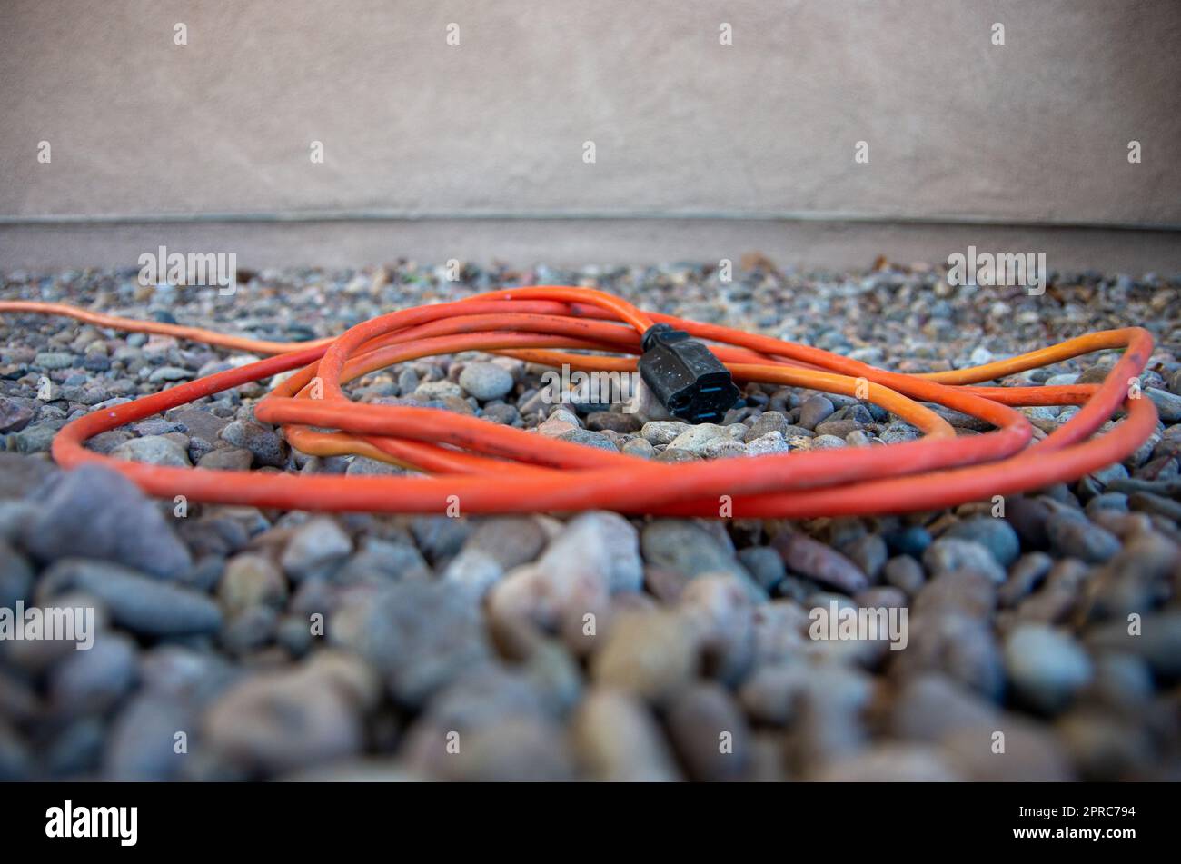 Orange Outdoor Extension Cord Sitting in Rock Bed Stock Photo - Alamy
