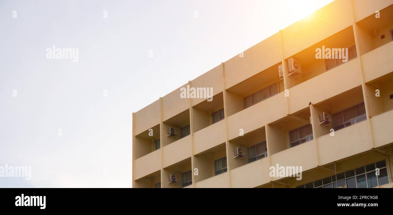 side view of yellow concrete building Intersect the orange sun Stock ...