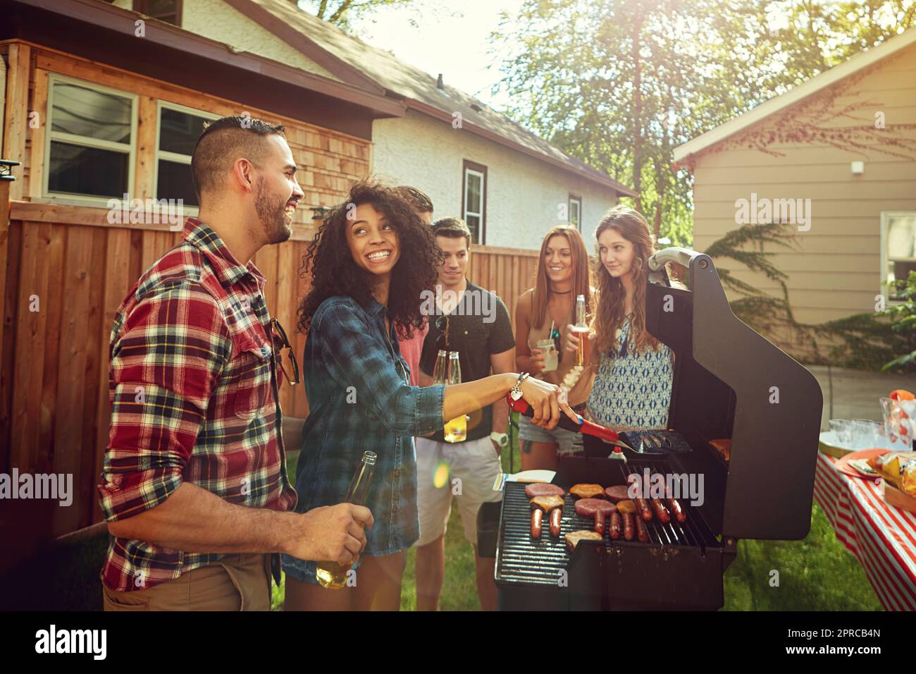 Getting some BBQ tips from the grillmaster. a group of friends having a ...