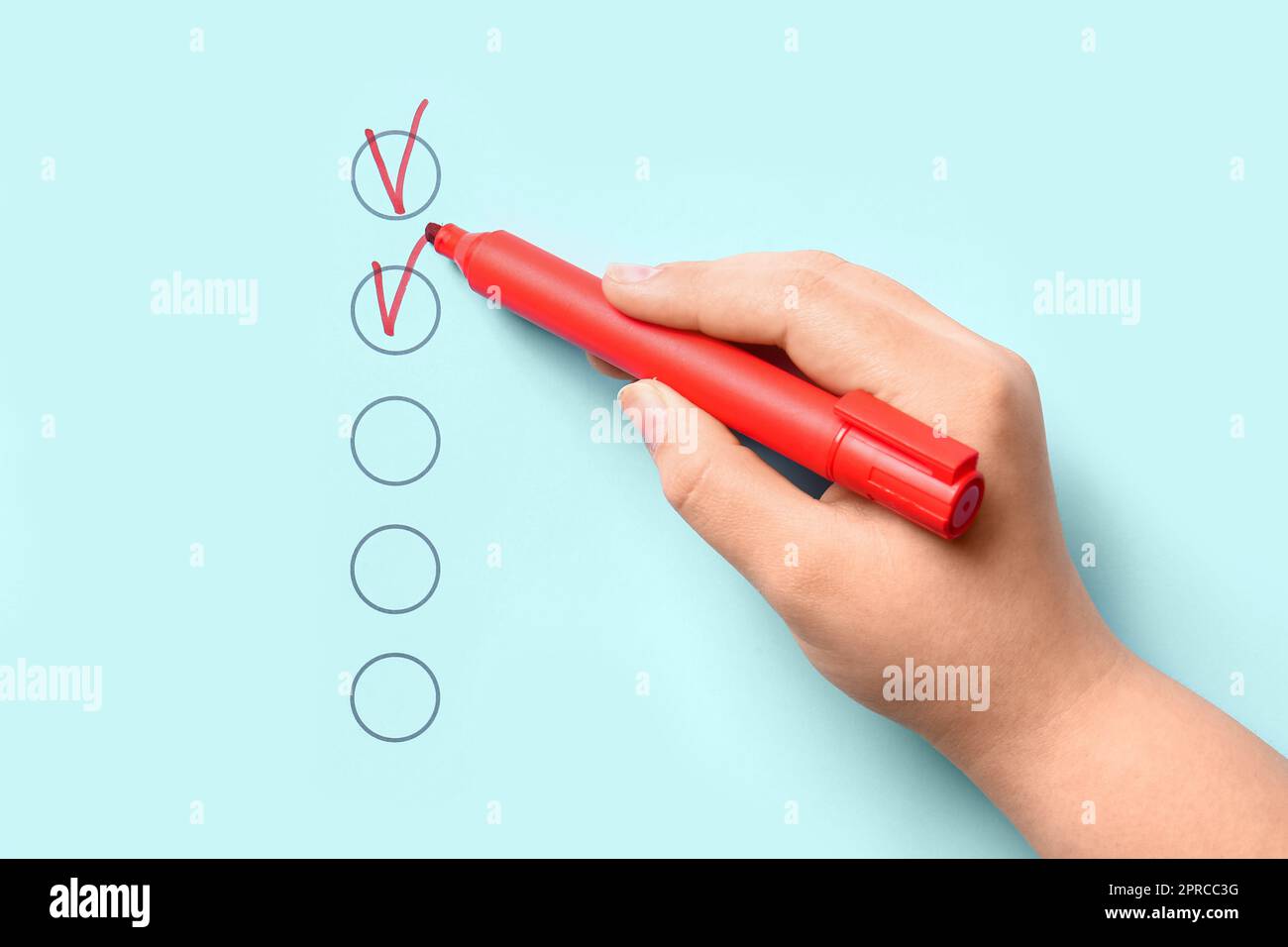 Woman marking on checklist box with red marker Stock Photo - Alamy