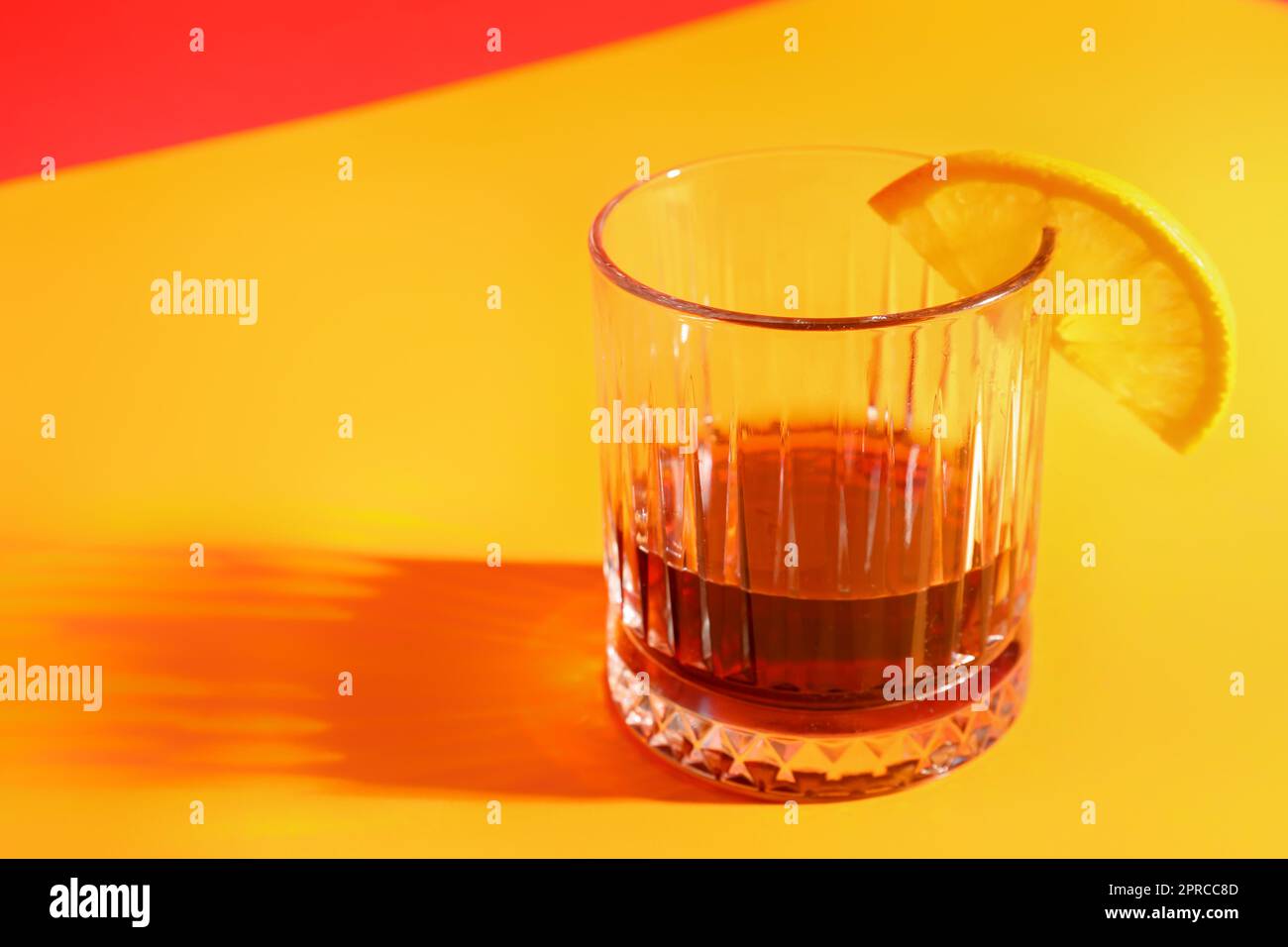 Glass of rum with lemon slice on orange background, closeup Stock Photo ...