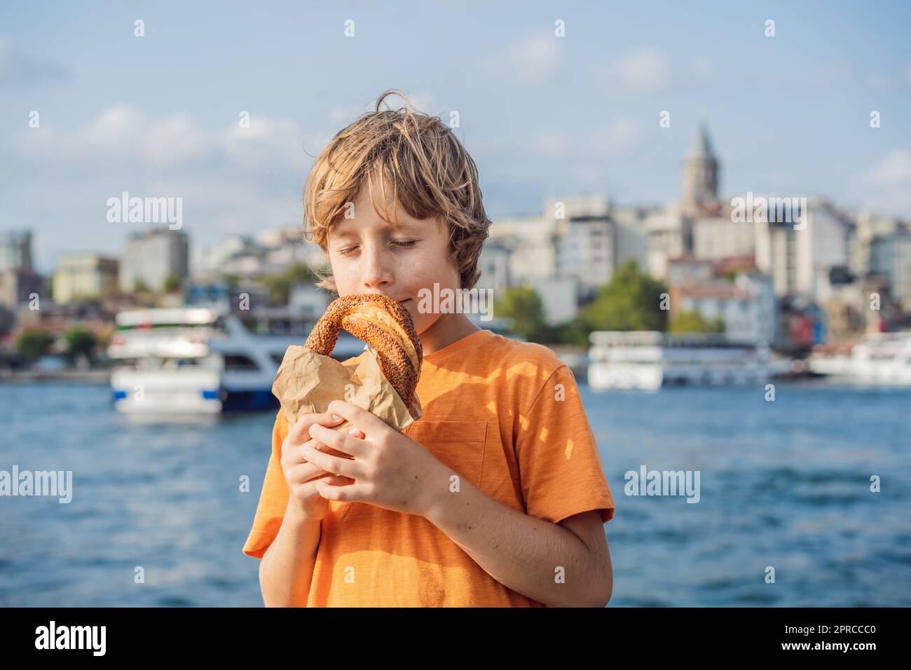 Boy in Istanbul having breakfast with Simit and a glass of Turkish tea ...