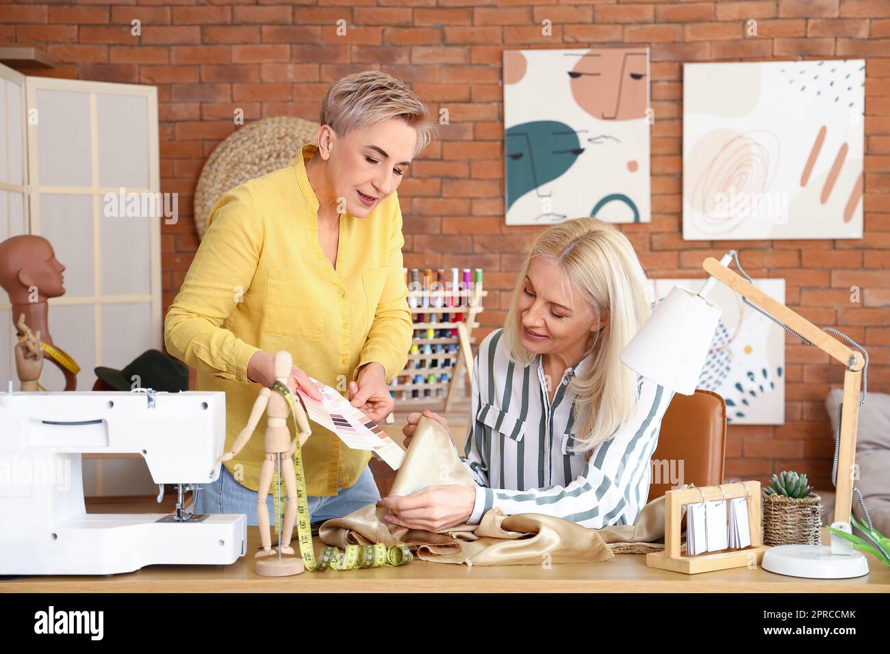 Female tailors working together in atelier Stock Photo - Alamy
