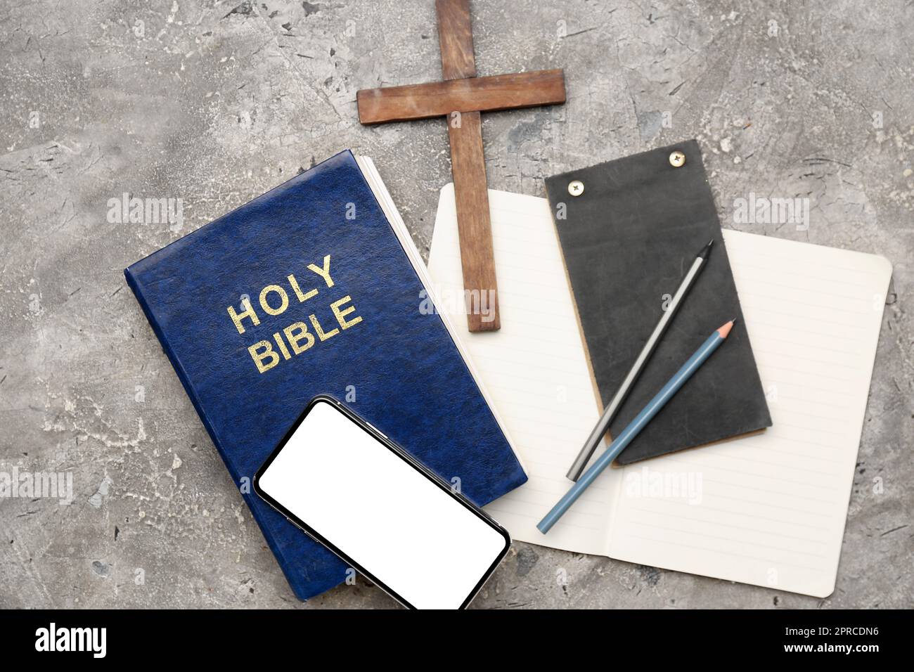 Holy Bible with mobile phone, notebooks and cross on grunge background ...