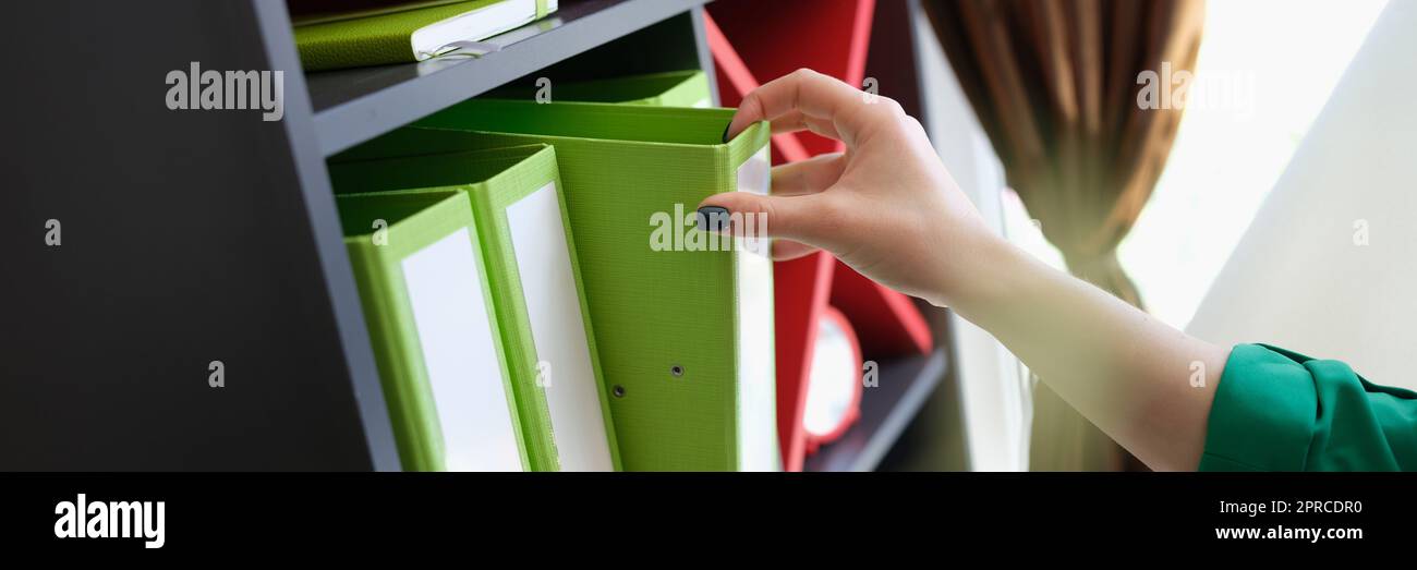 Female hands taking off green folder with documents Stock Photo - Alamy