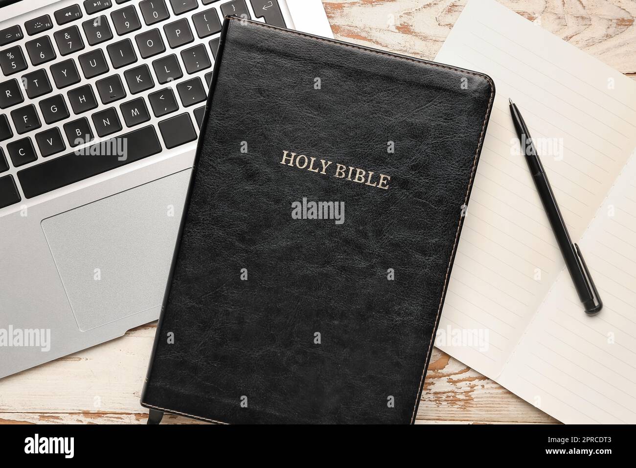 Holy Bible with notebook and laptop on white wooden background Stock ...