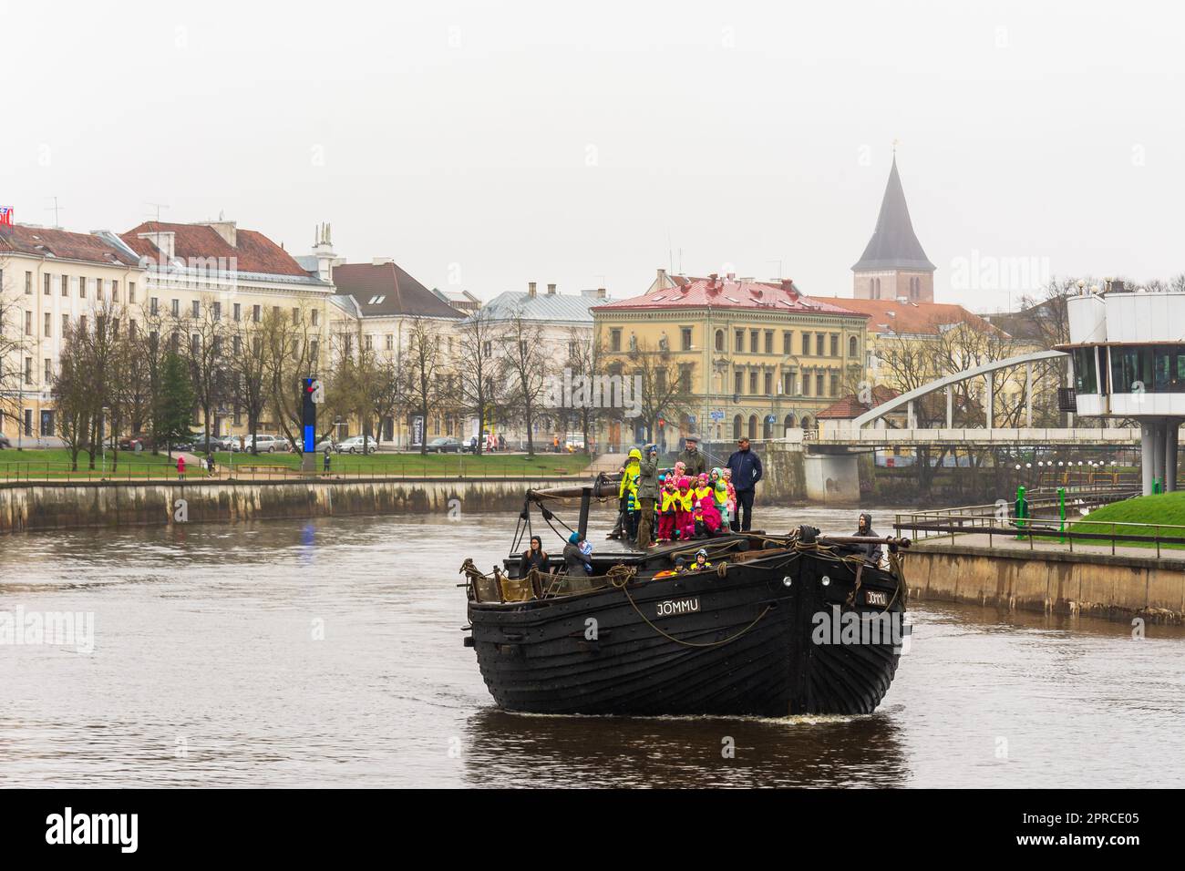 Children on the deck of an old boat on Emajogi river in rainy weather ...