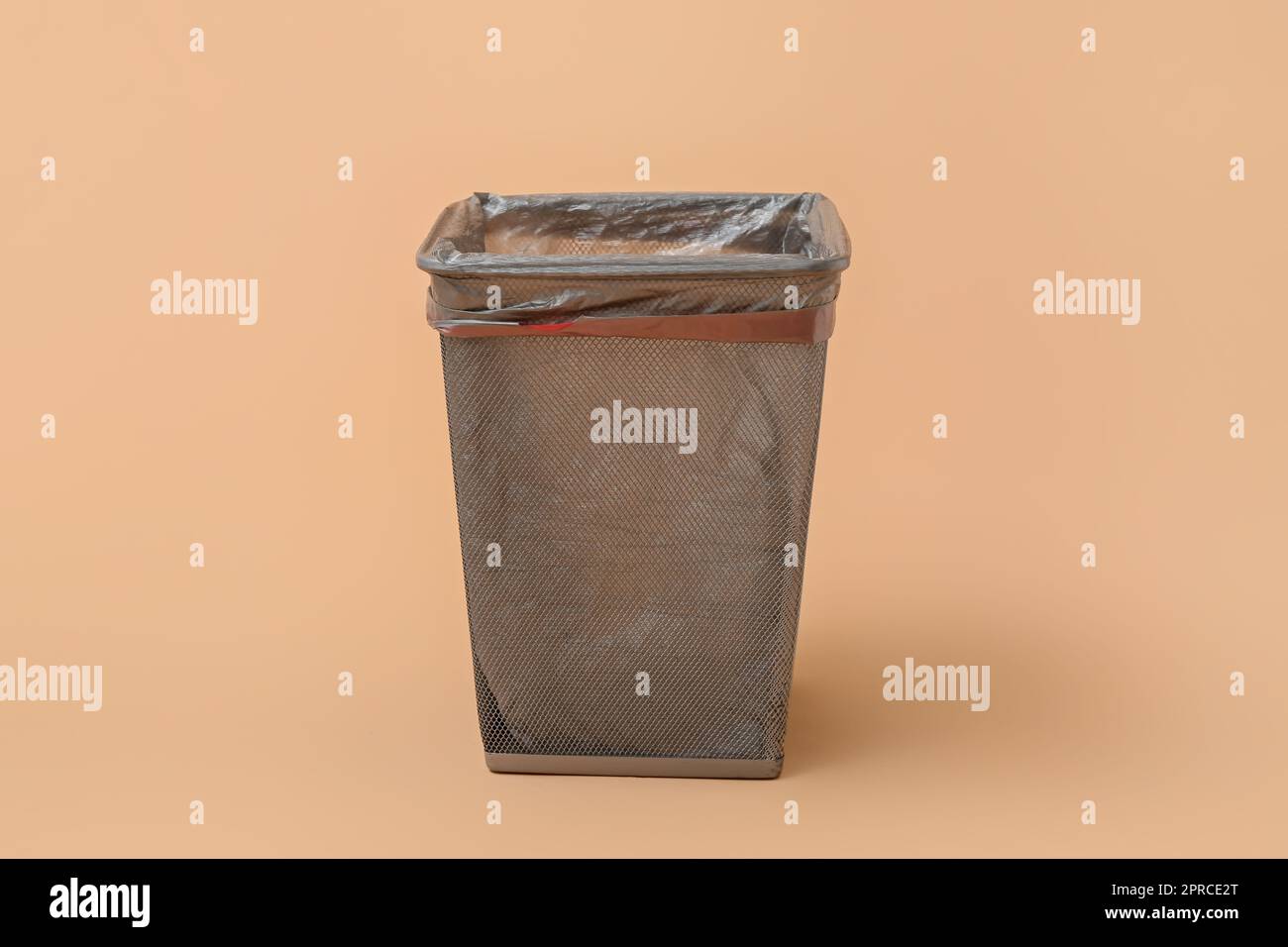 Empty trash bin with garbage bag on beige background Stock Photo - Alamy