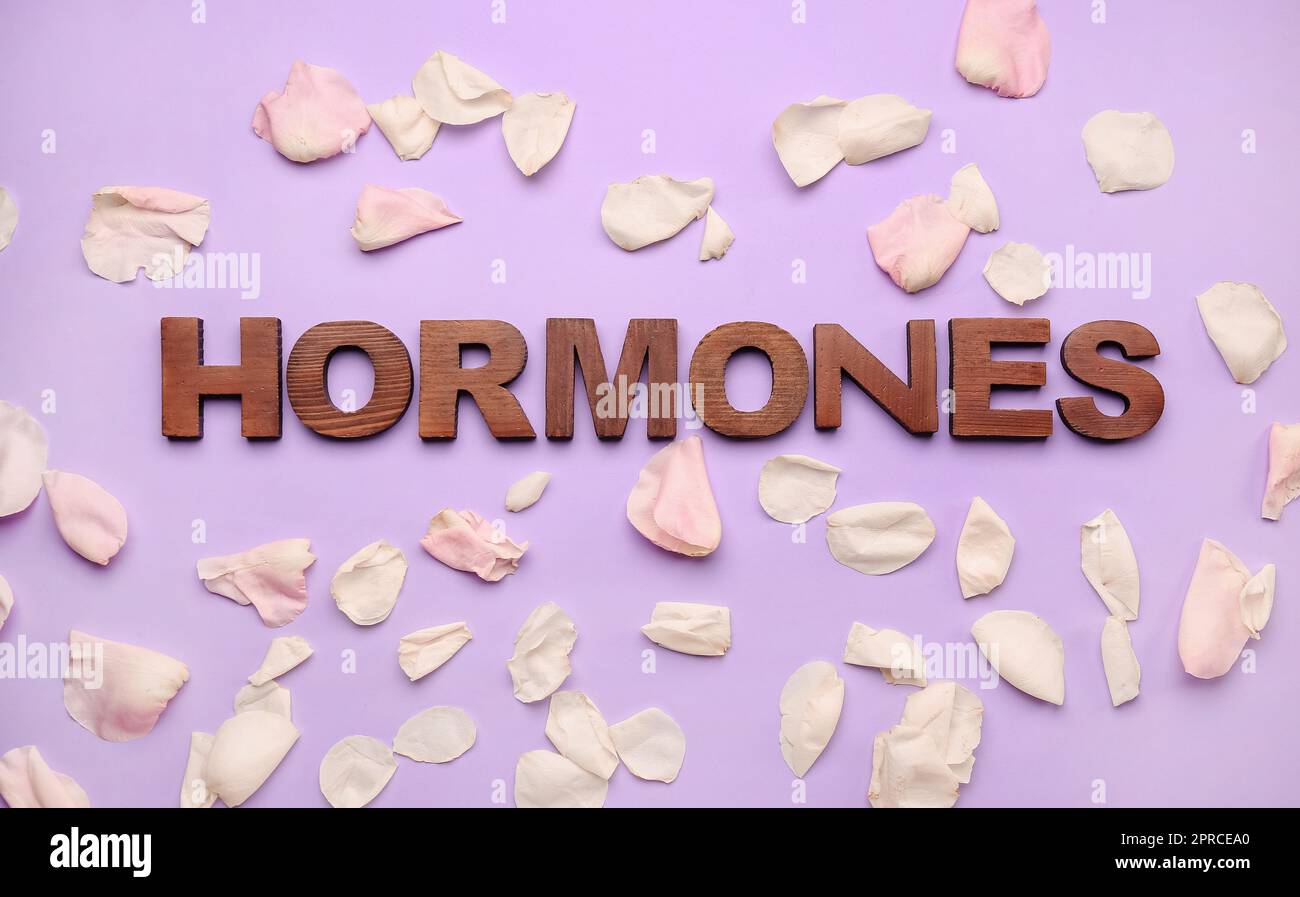 Word HORMONES with floral petals on lilac background Stock Photo - Alamy