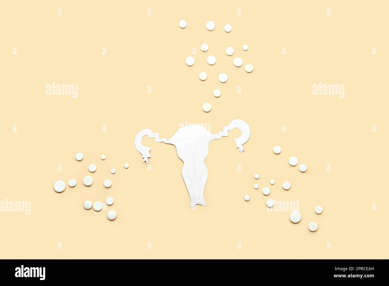 Paper uterus with hormonal pills on beige background Stock Photo - Alamy