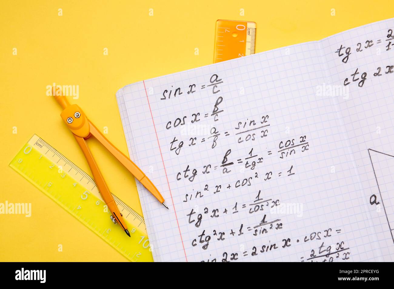 Copybook with maths formulas and stationery on yellow background Stock ...