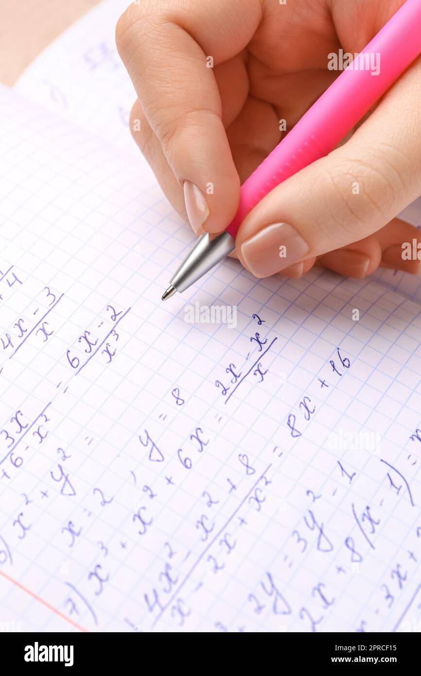 Woman writing maths formulas in copybook with pen, closeup Stock Photo ...
