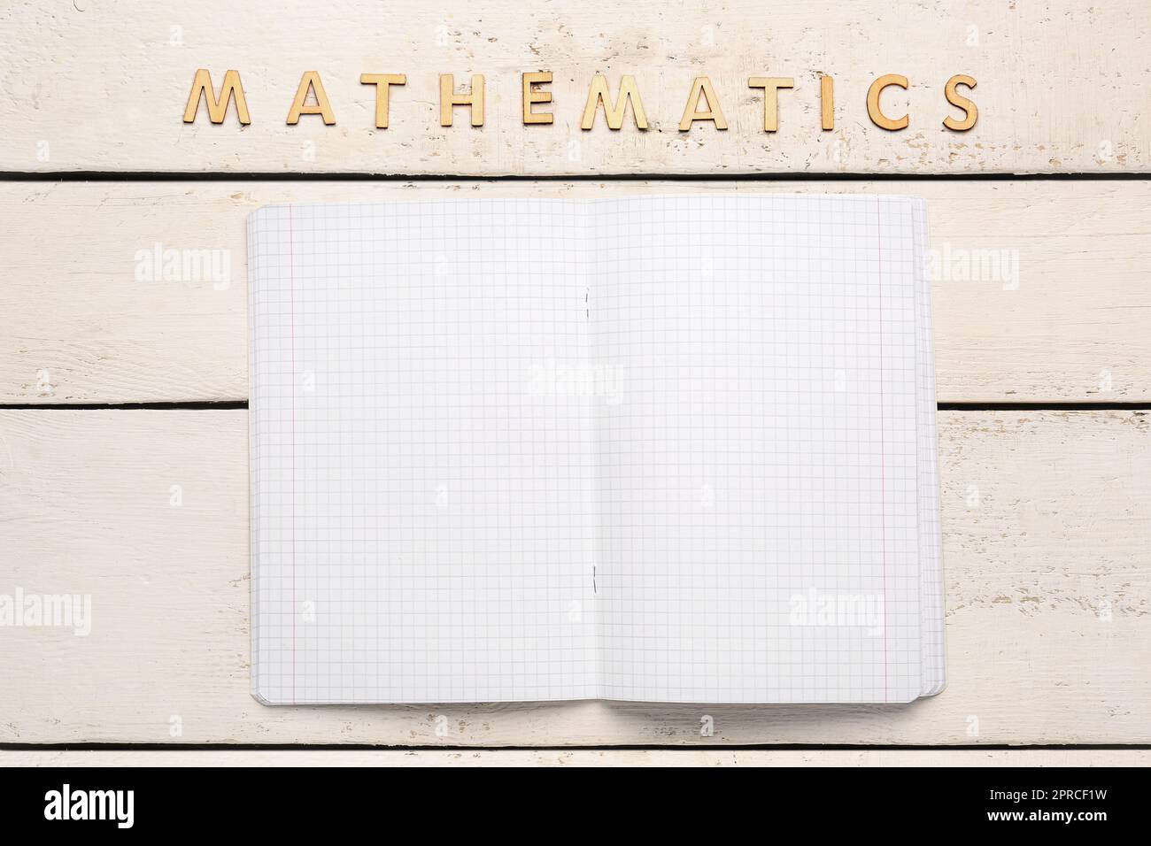 Blank copybook pages and text MATHEMATICS on white wooden background ...