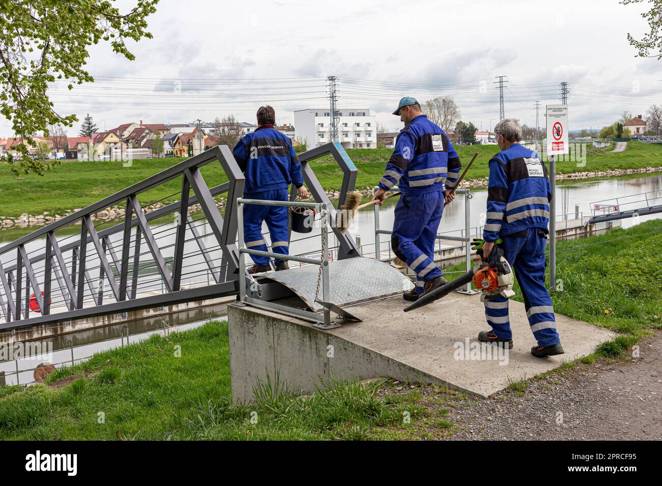 Three men in overalls go to clean the river bank Stock Photo - Alamy