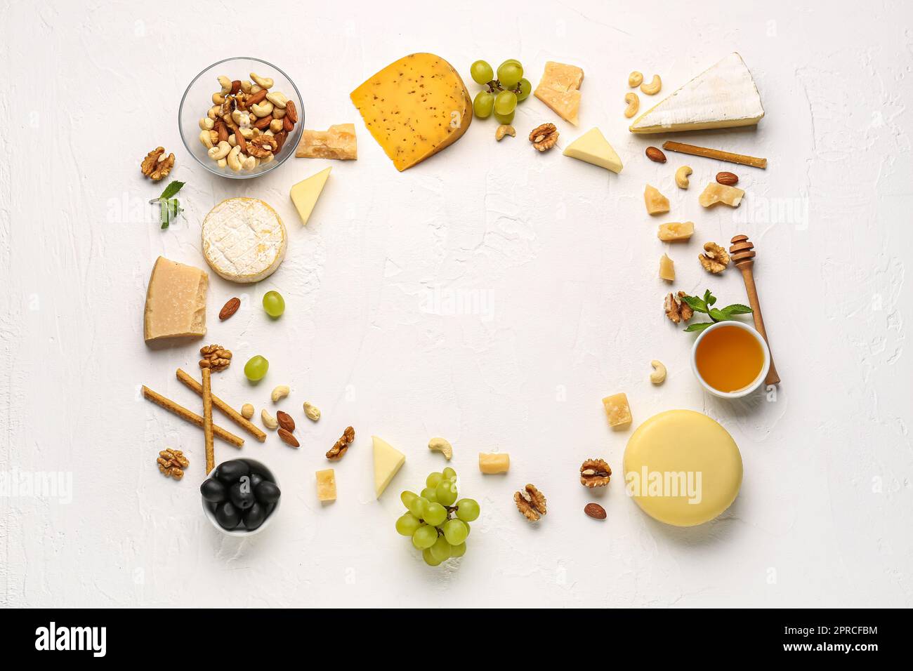 Frame made of different types of tasty cheese, nuts and honey on light ...