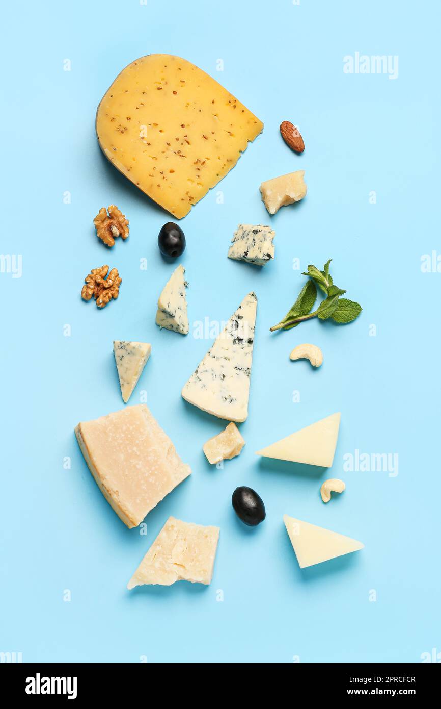 Different types of tasty cheese and nuts on blue background Stock Photo ...