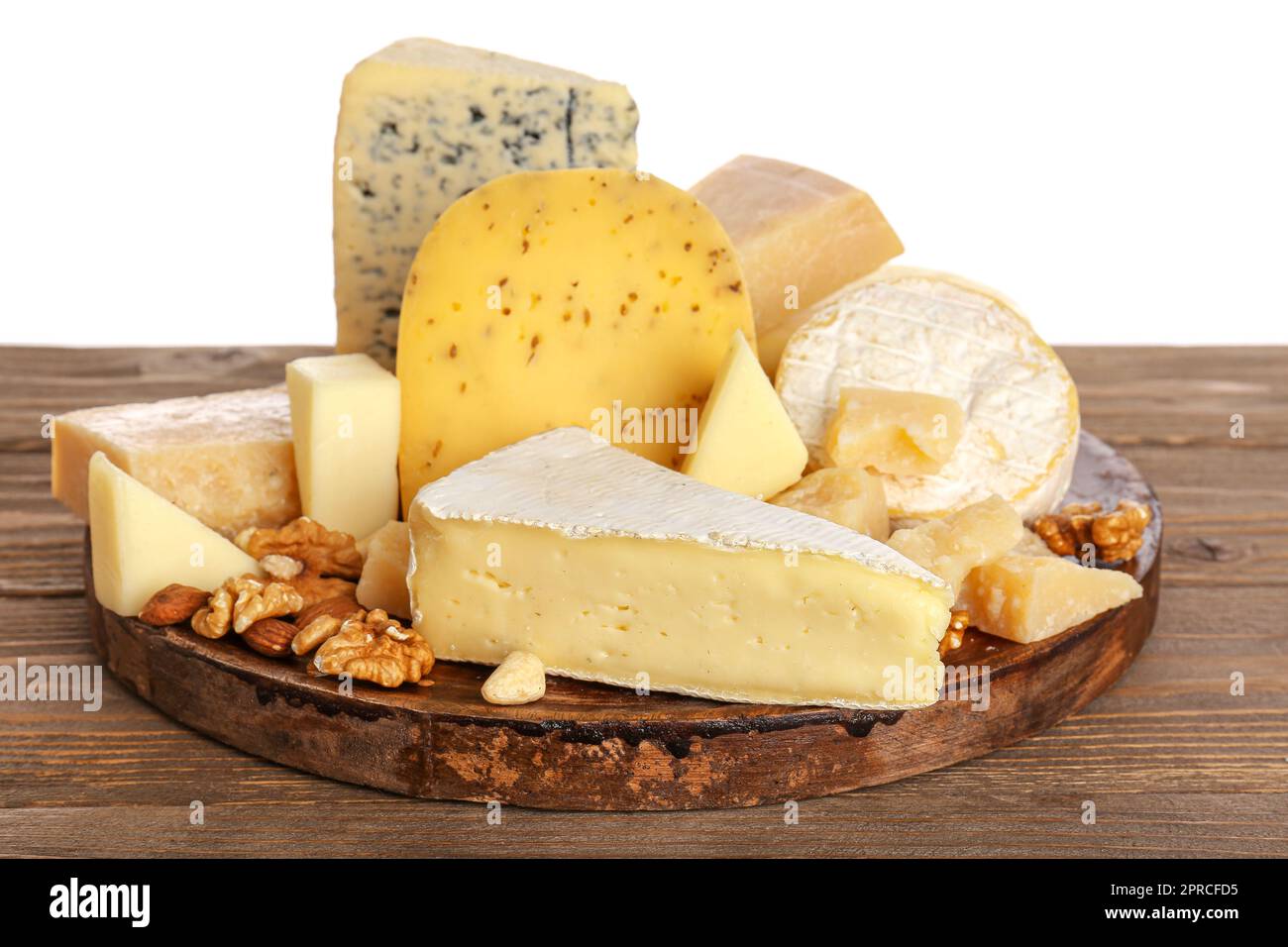 Plate with different types of tasty cheese on table against white ...