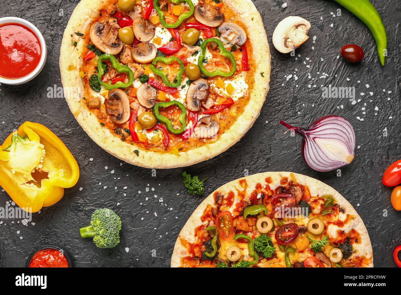 Vegetables pizzas with ingredients and sauces on dark background Stock ...