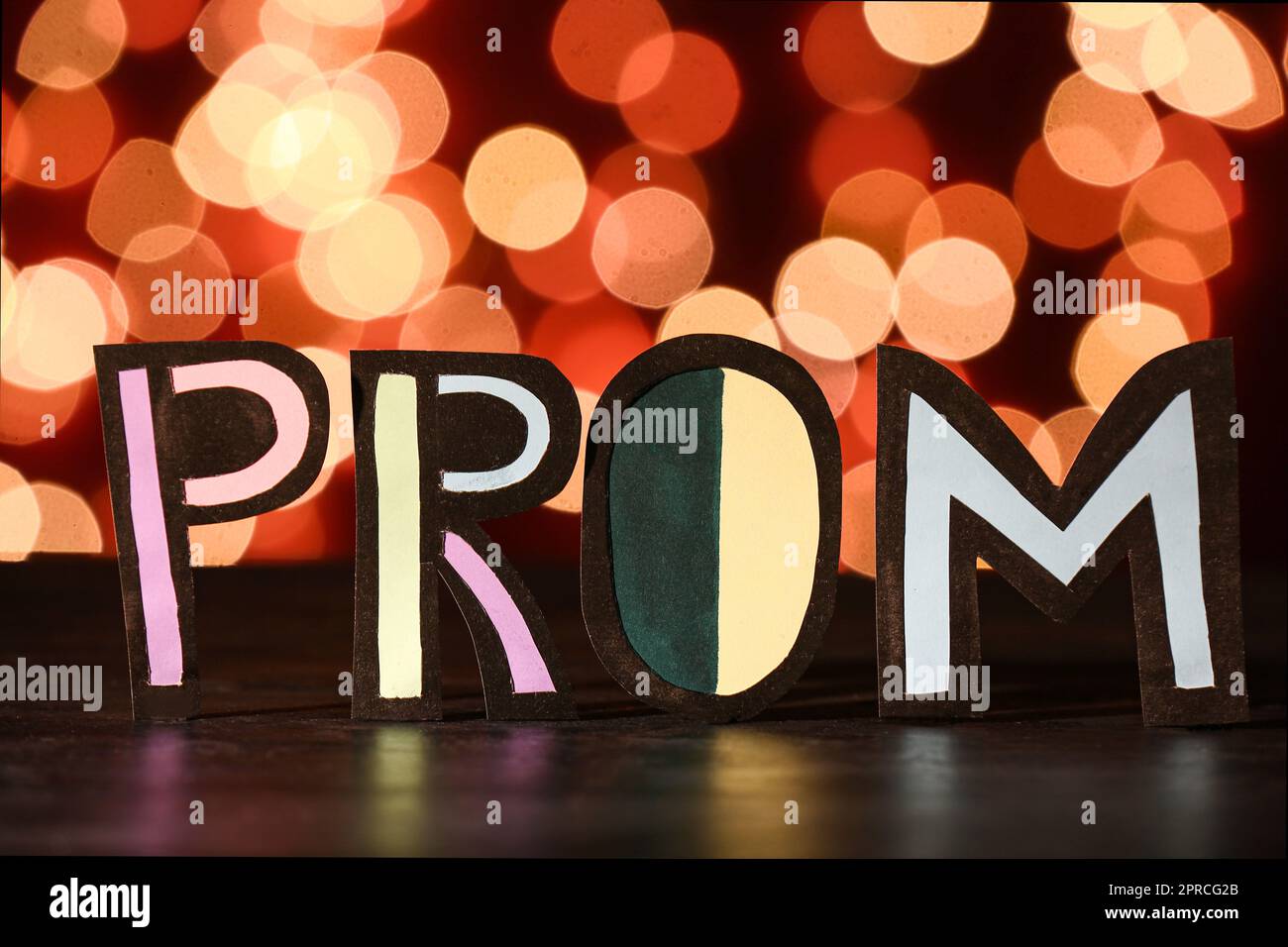 Word PROM on dark table against blurred lights Stock Photo - Alamy