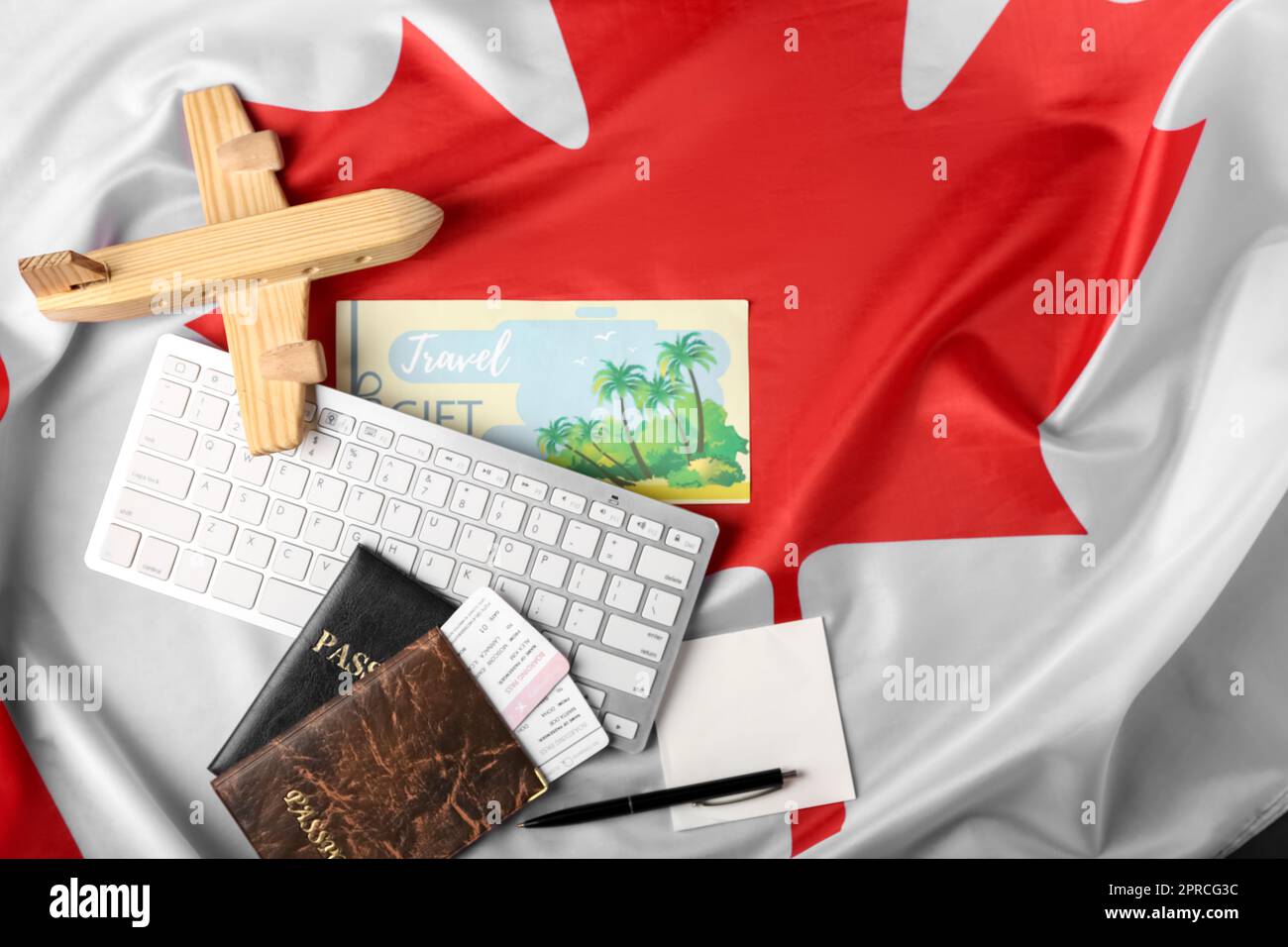 Computer keyboard with passports, tickets, wooden airplane and sticky ...