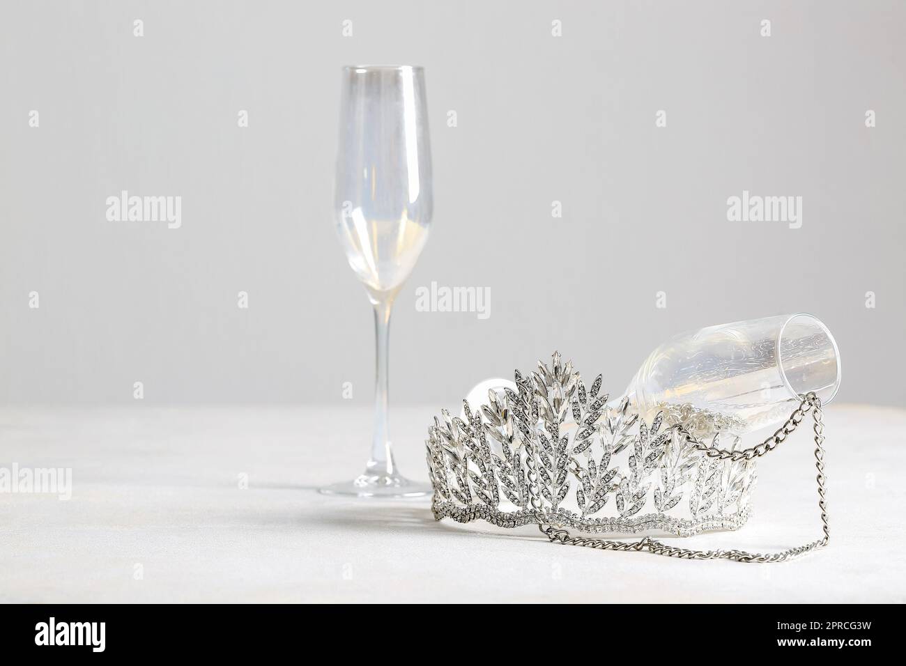 Beautiful tiara, glasses and necklace on white table. Prom concept ...