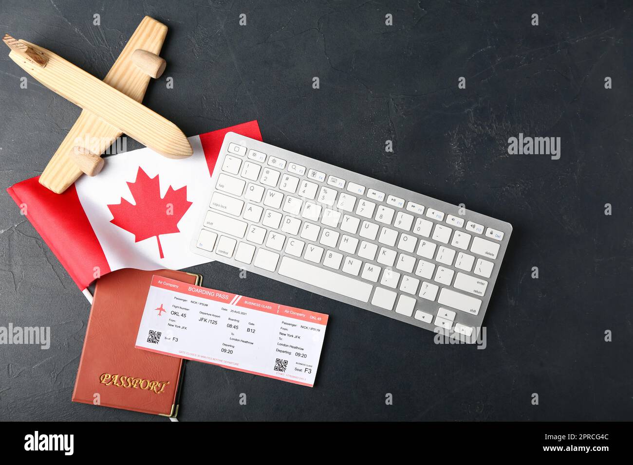 Canadian flag with wooden airplane, passport, ticket and computer ...