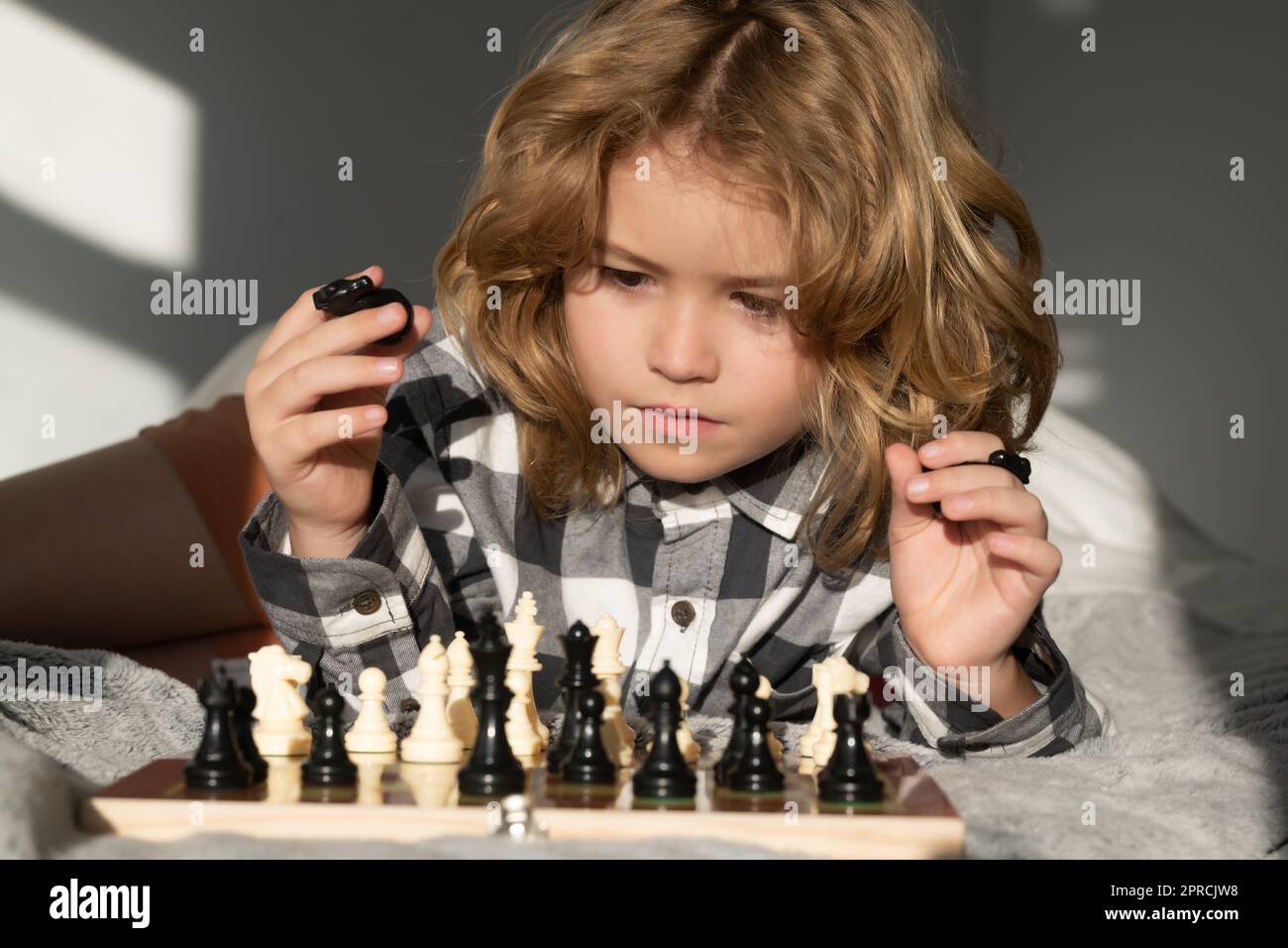 Clever thinking child. Clever concentrated and thinking kid playing ...