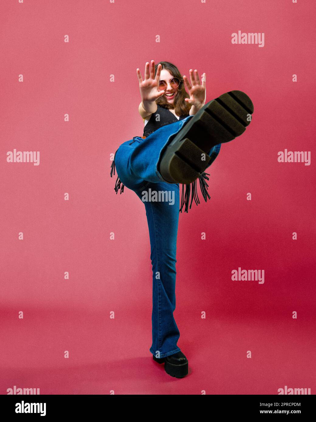 Teenage Girl in 70s Style Outfit Kicking Foot Towards Camera Hands Up ...