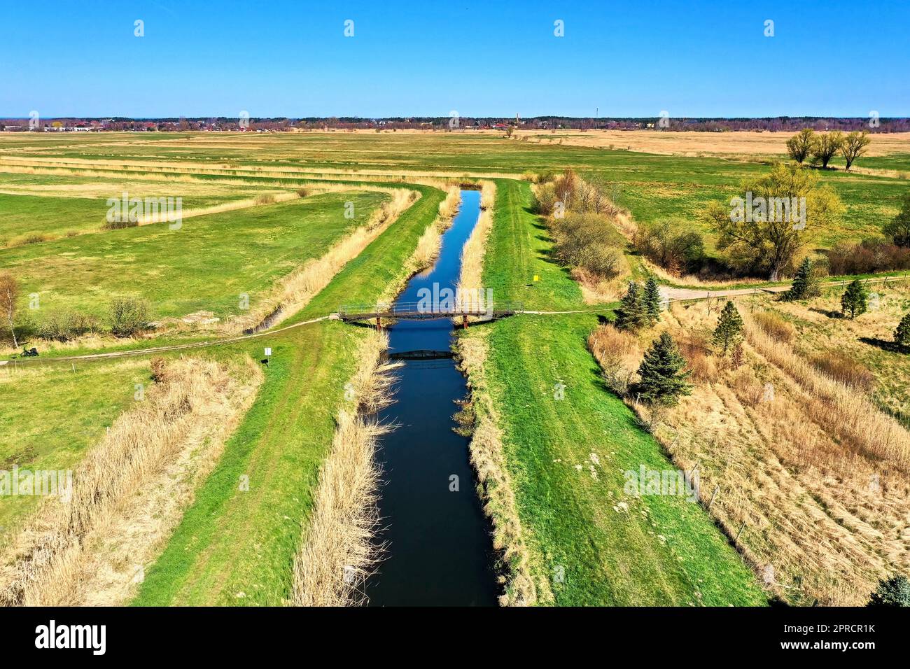 Aerial view of a dam secured drainage ditch with a narrow bridge for ...