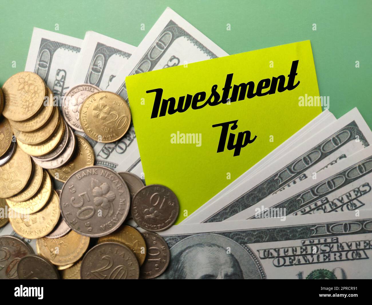 Coins,banknotes and colored note with the word Investment Tip Stock ...