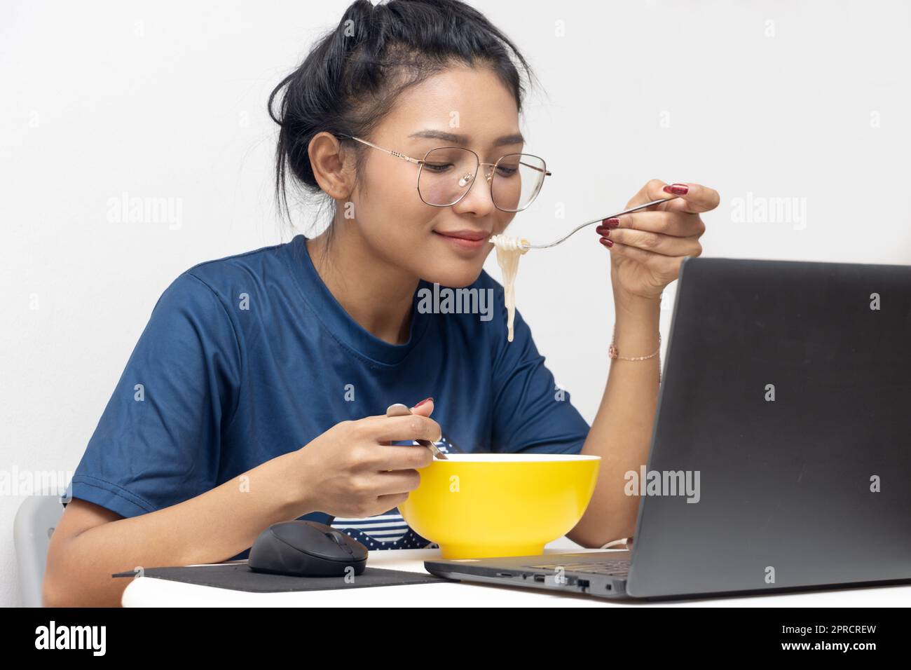 Asian businesswoman eating at computer hi-res stock photography and ...