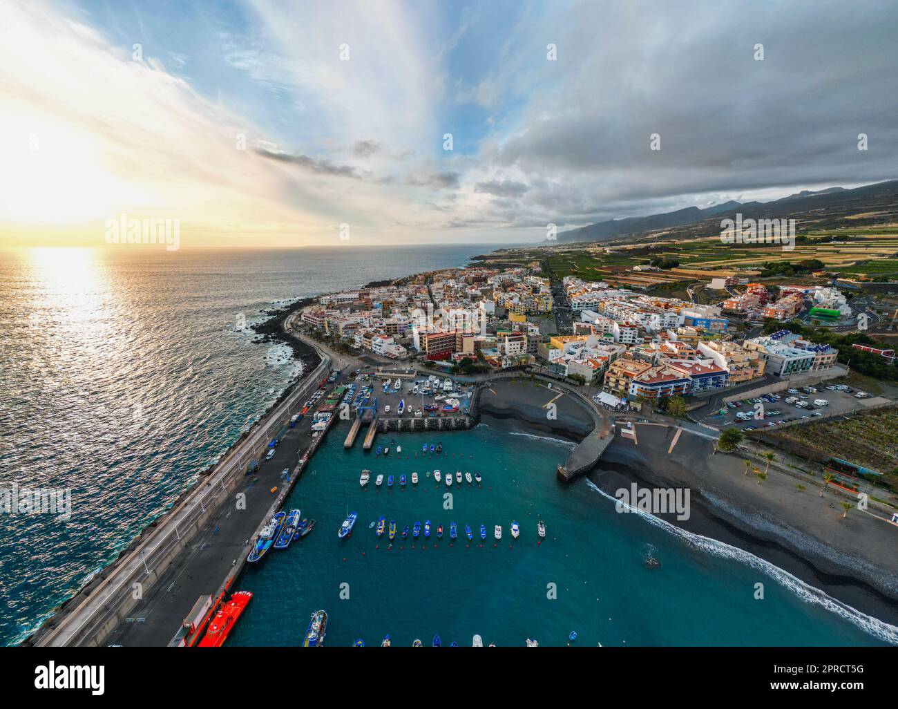 An aerial view of a bustling port city at sunset, with a multitude of ...