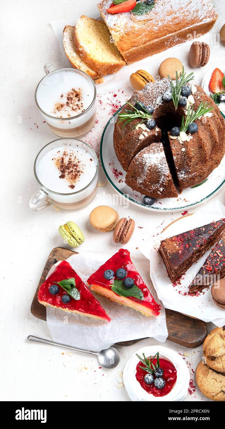 Dessert table with various of bundt cakes, pieces of cakes, sweets ...