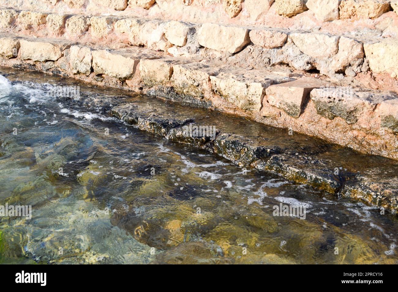 Old ancient yellow stone steps covered with green mud and mud, descent ...
