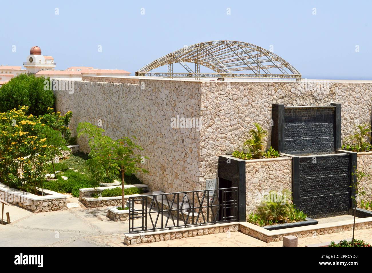 A large stone brown building is square with a spherical semicircular ...