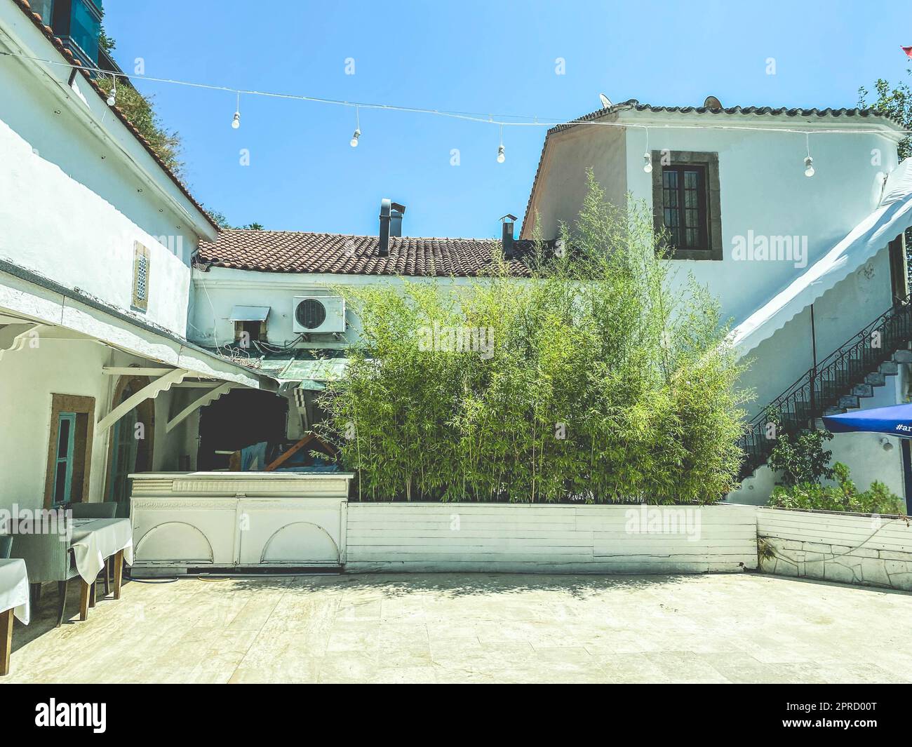 two-story white building with red tiles and air conditioning on the ...