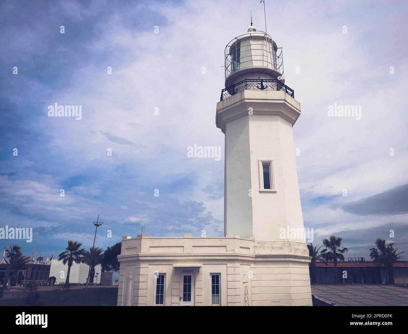 Big tall stone white lighthouse on the tropical sea warm summer resort ...