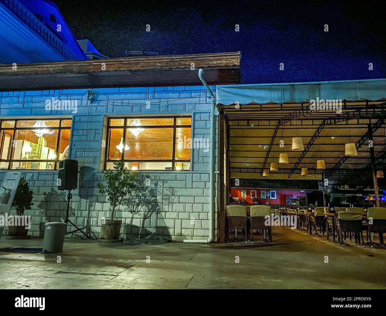 white brick building on the beach with burning windows. evening at the ...