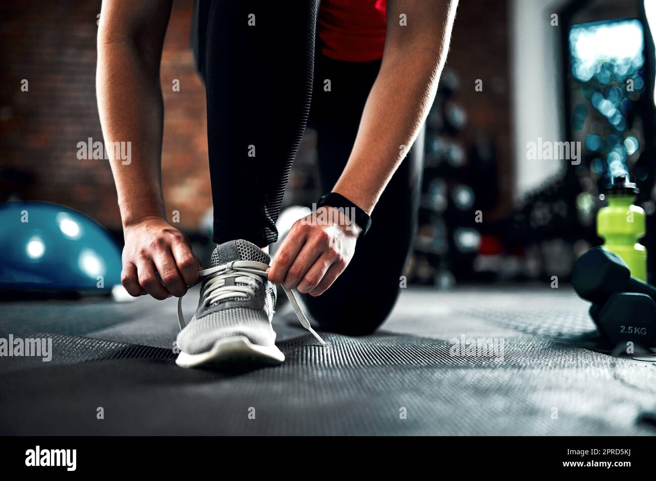 Ready for a workout. an unrecognizable young female athlete tying her ...