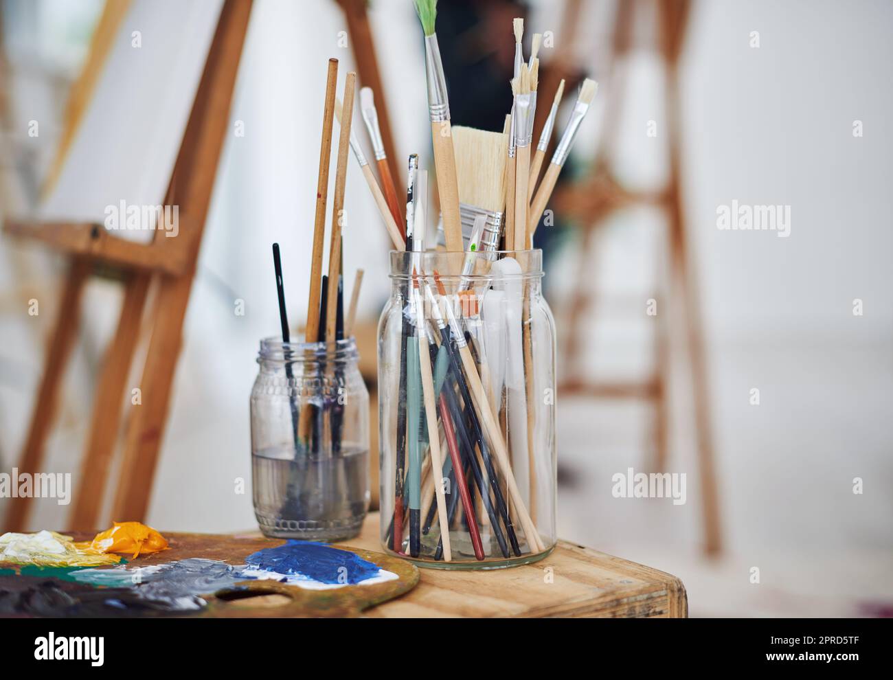 Let the brush guide you. Still life shot of paintbrushes in jars in a ...