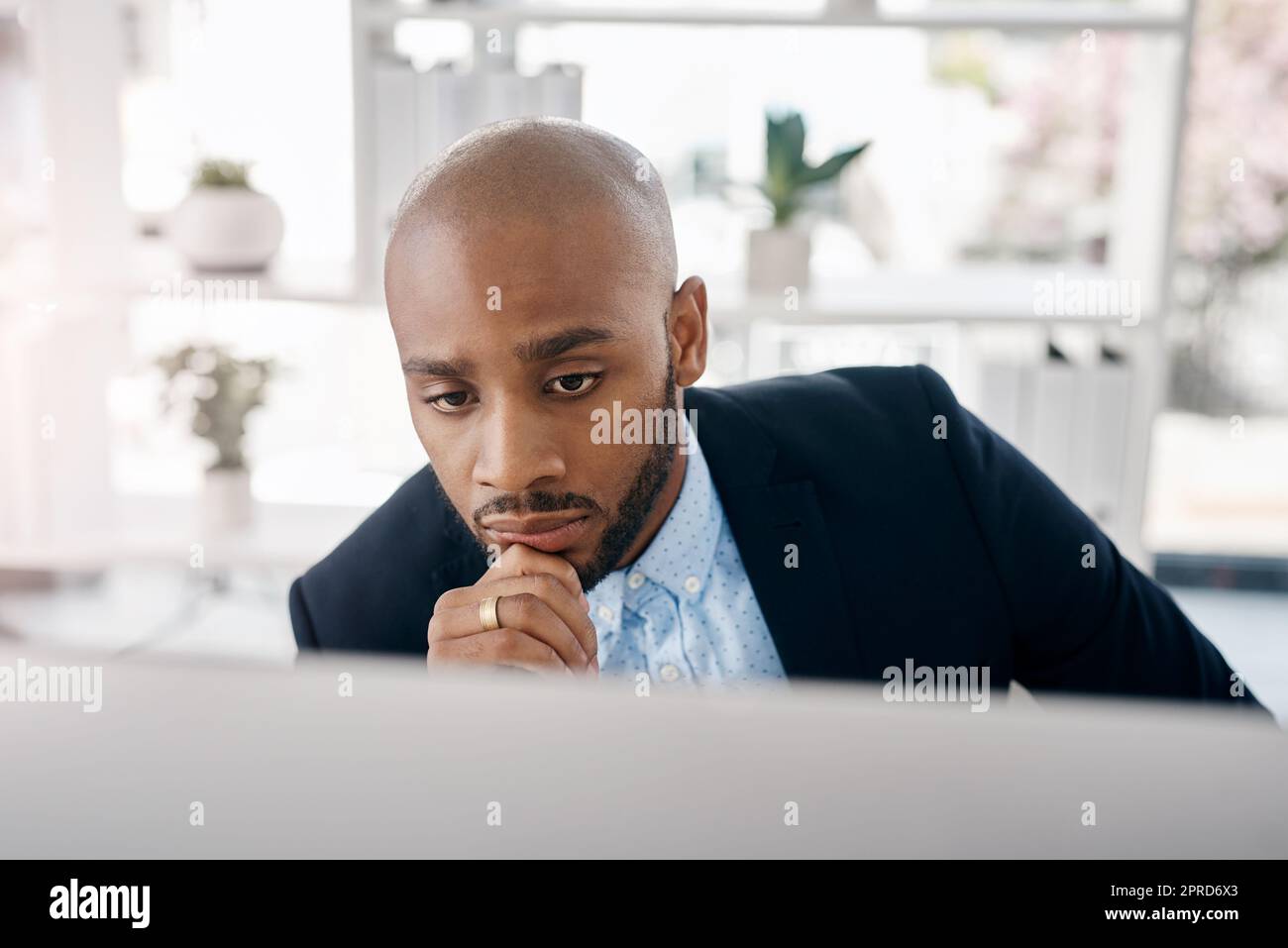Waiting for inspiration to strike. a young businessman staring at his ...